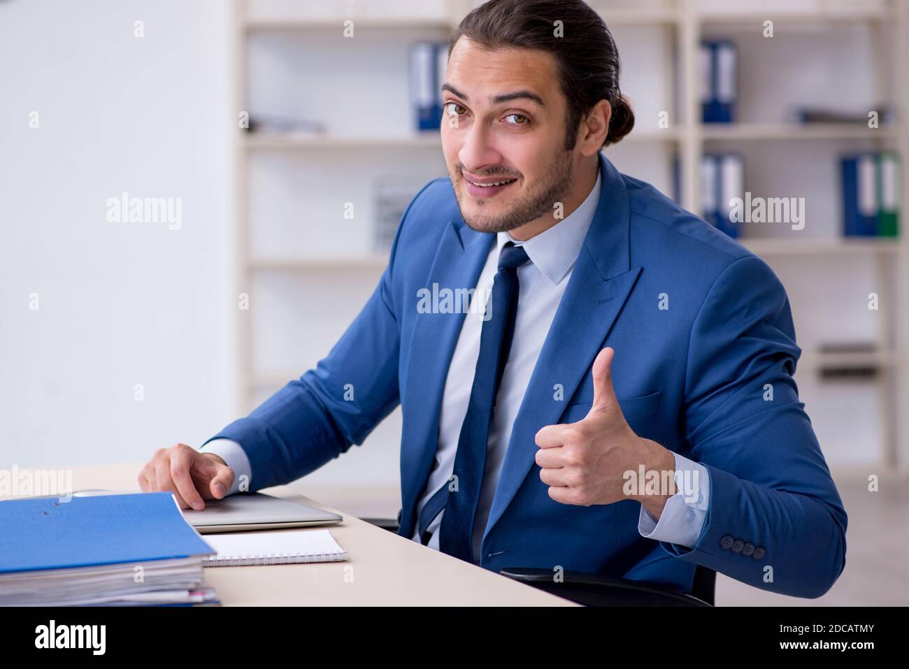 Young employee working at workplace Stock Photo - Alamy