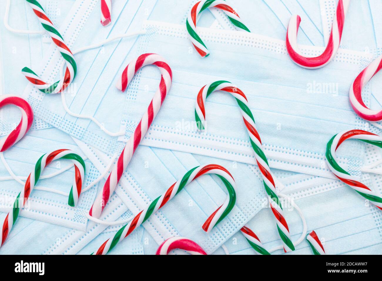 Blue medical face masks and colorful candy canes on top of them, top ...