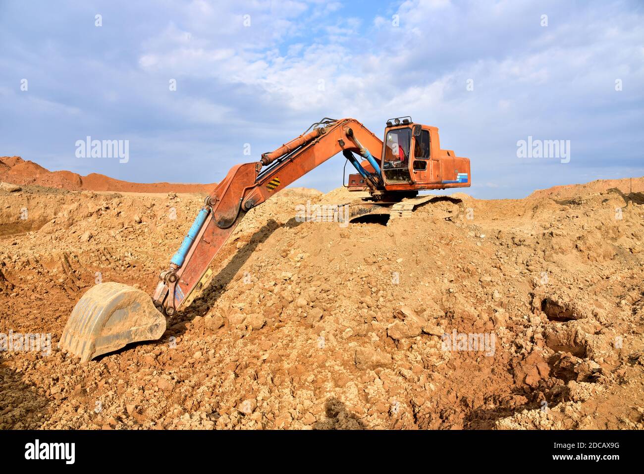 Excavator working on earthmoving at open pit mining. Backhoe digs ...