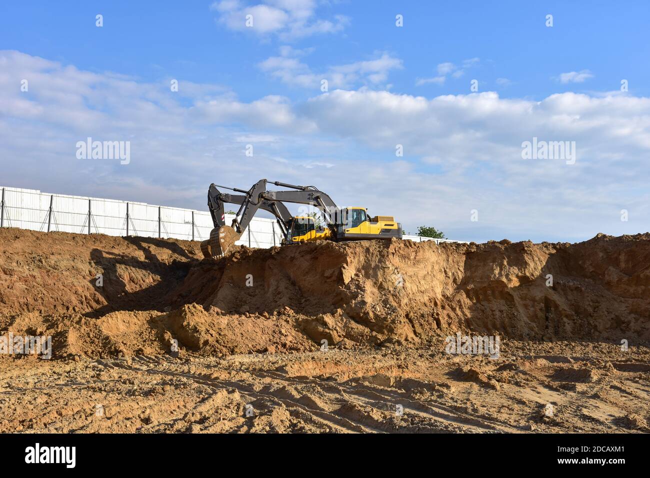 Excavators during earthworks at construction site. Backhoe the digging ...