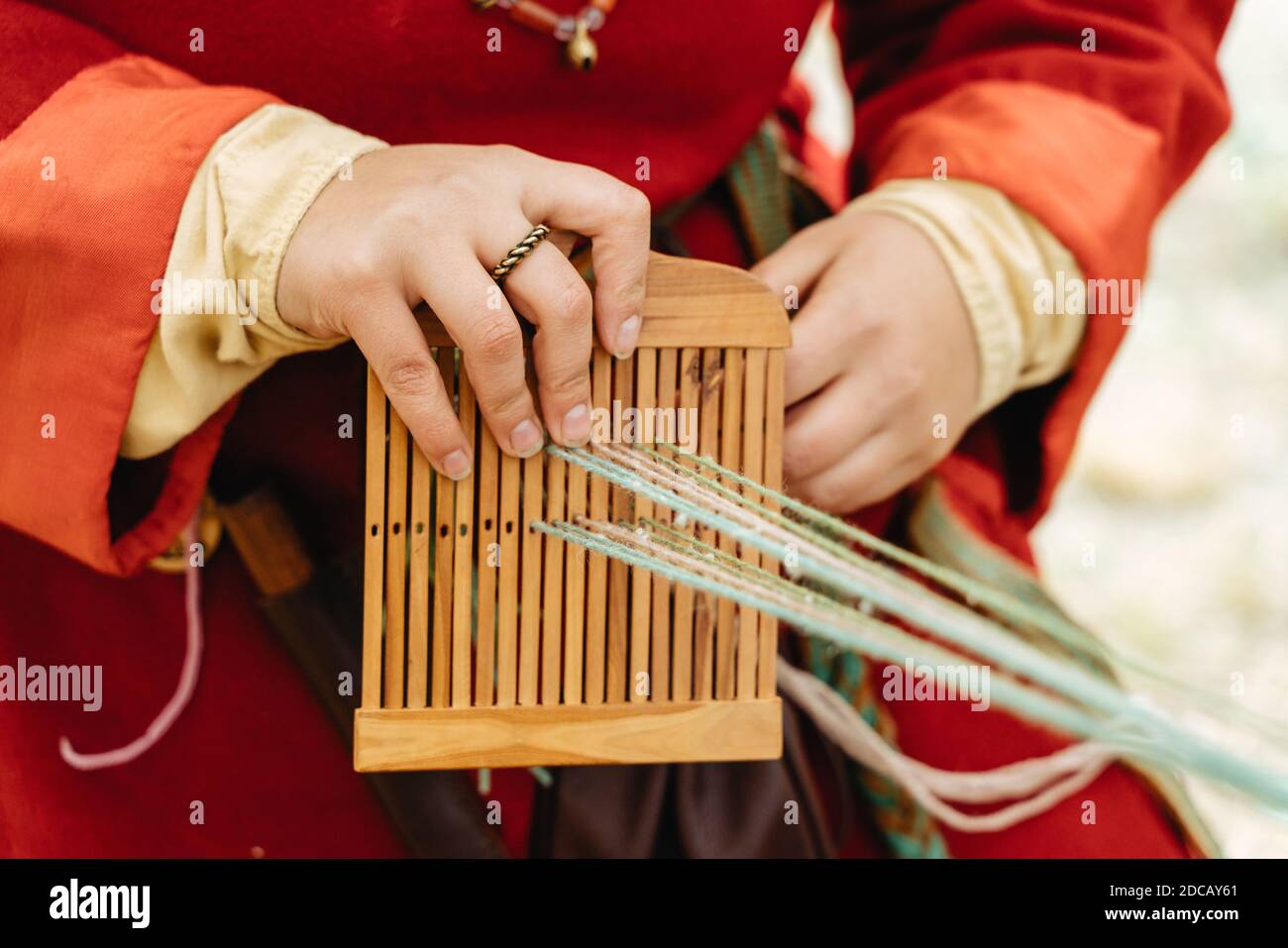 Weaving craft. Woman in traditional dress works with hands Stock Photo ...