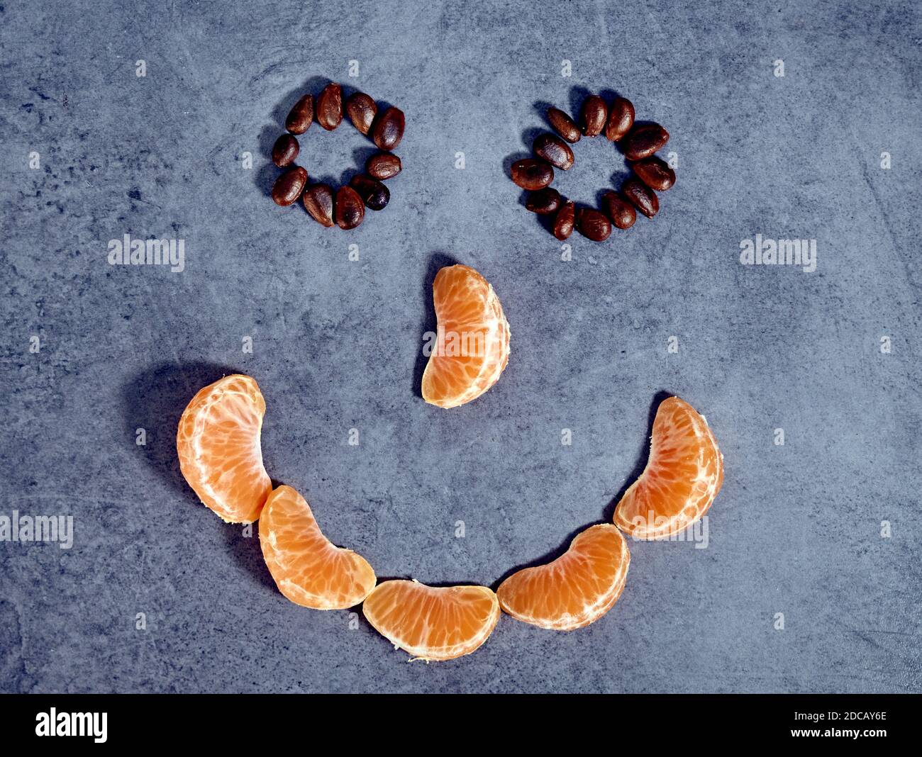 A high angle shot of tangerine pieces and seeds shaped like a smiley ...
