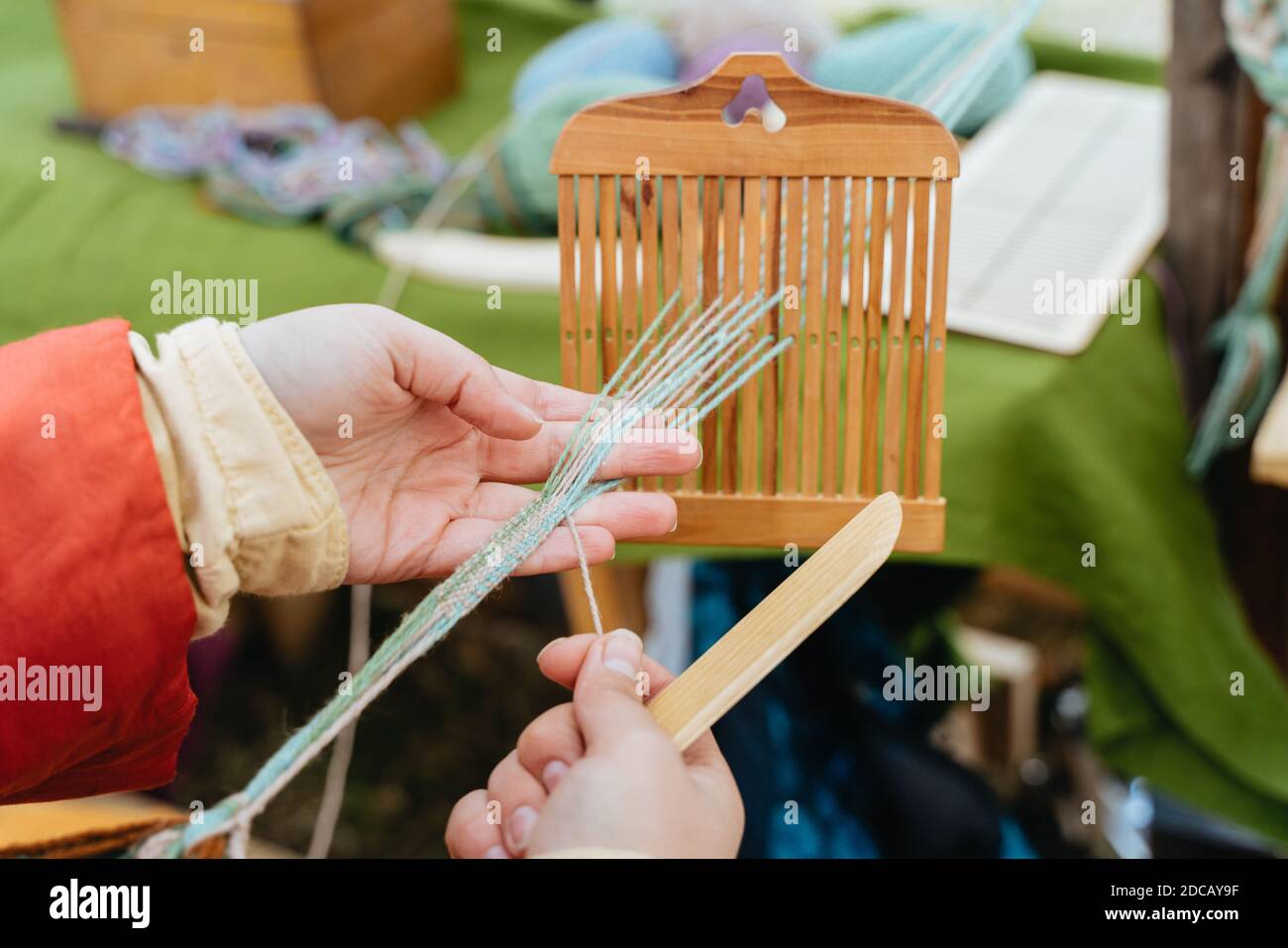 Weaving craft. Woman in traditional dress works with hands Stock Photo ...