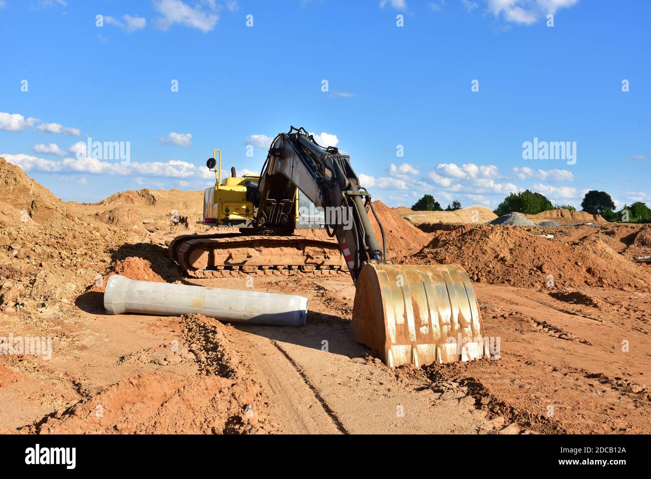 Excavator working at construction site. Backhoe digs ground for the ...