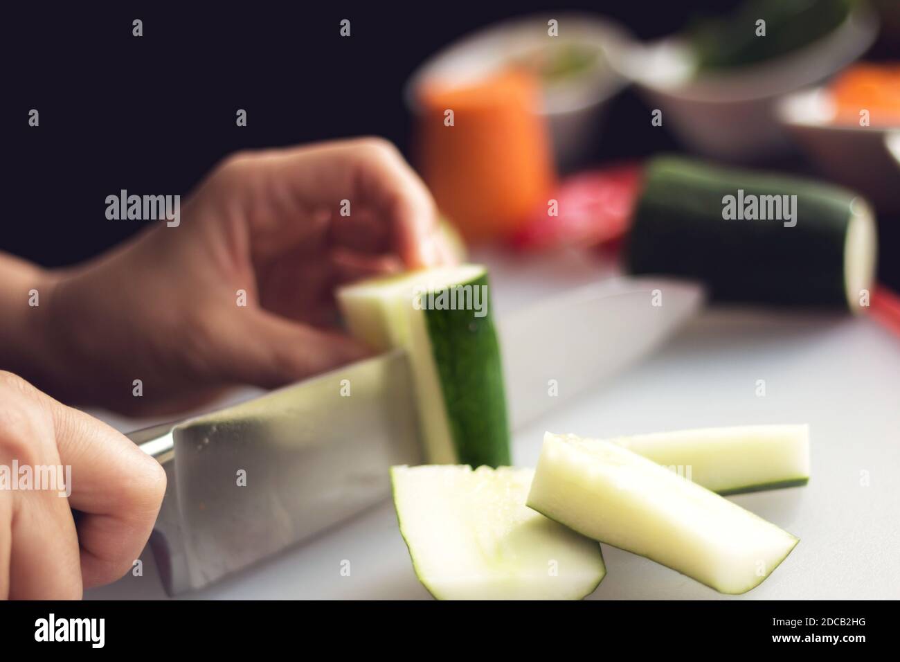 A closeup shot of a female cutting cucumber in the kitchen Stock Photo ...