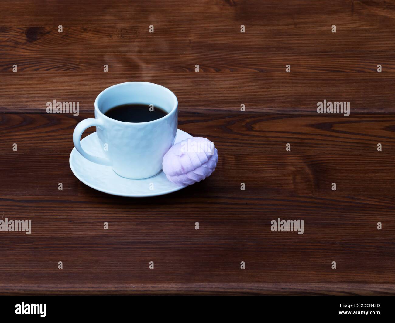 White cup of coffee and pink zefir on the wooden background ...