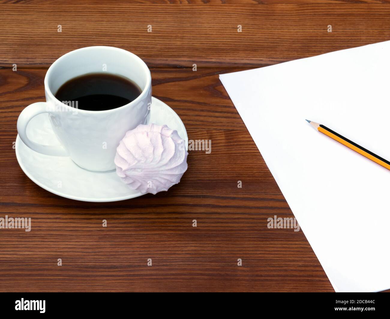 White cup of coffee and pink zefir on the wooden background ...
