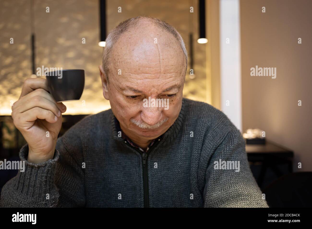 Portrait of a tired old man with a cup of coffee at a cafe Stock Photo ...