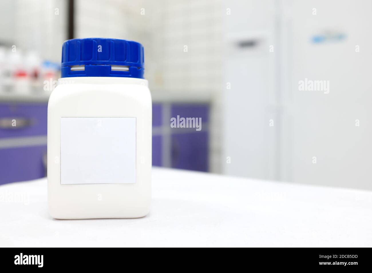 Unlabeled plastic chemical bottle container with cap in a white ...