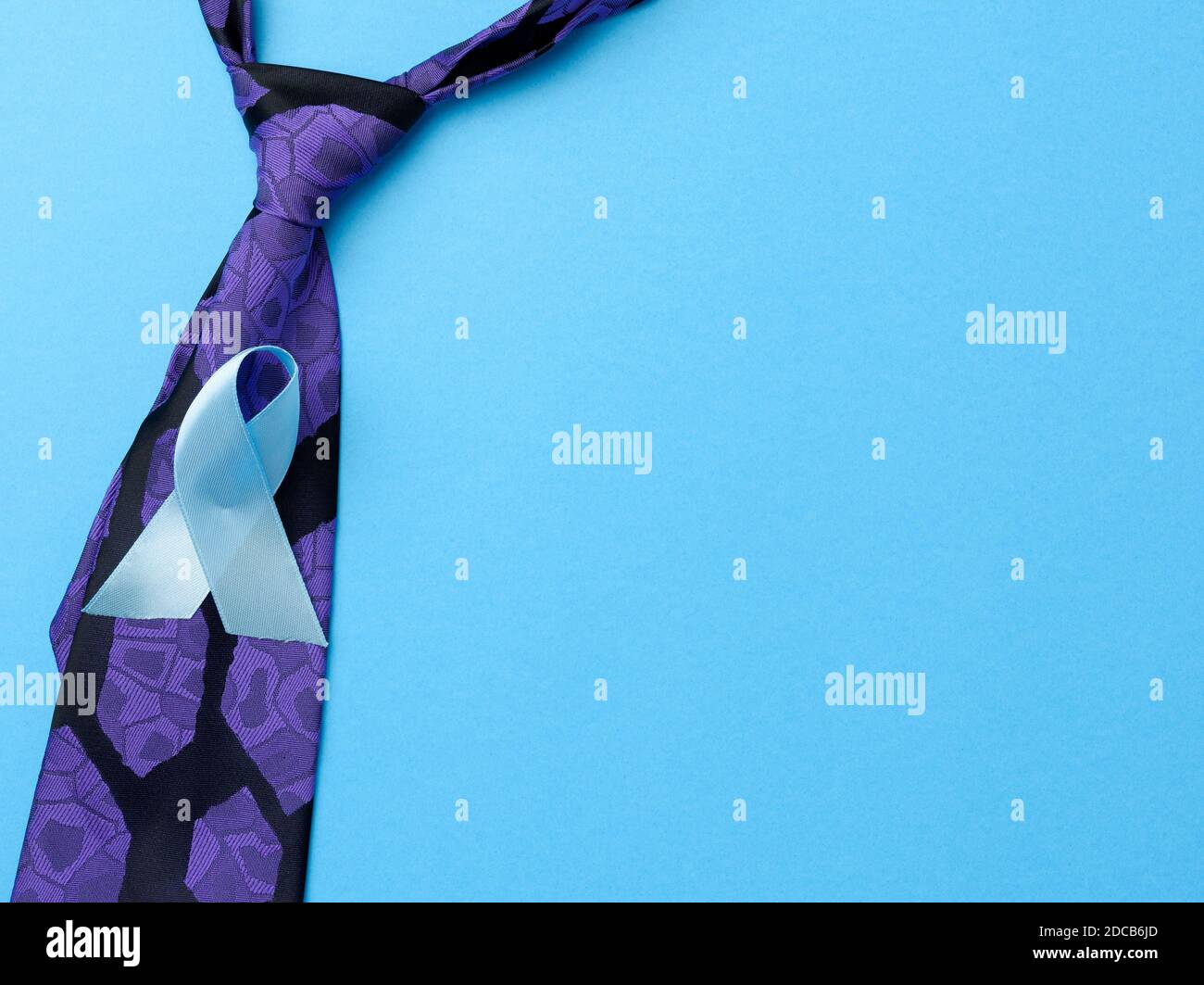 silk purple mens tie and blue ribbon folded in a loop on blue ...