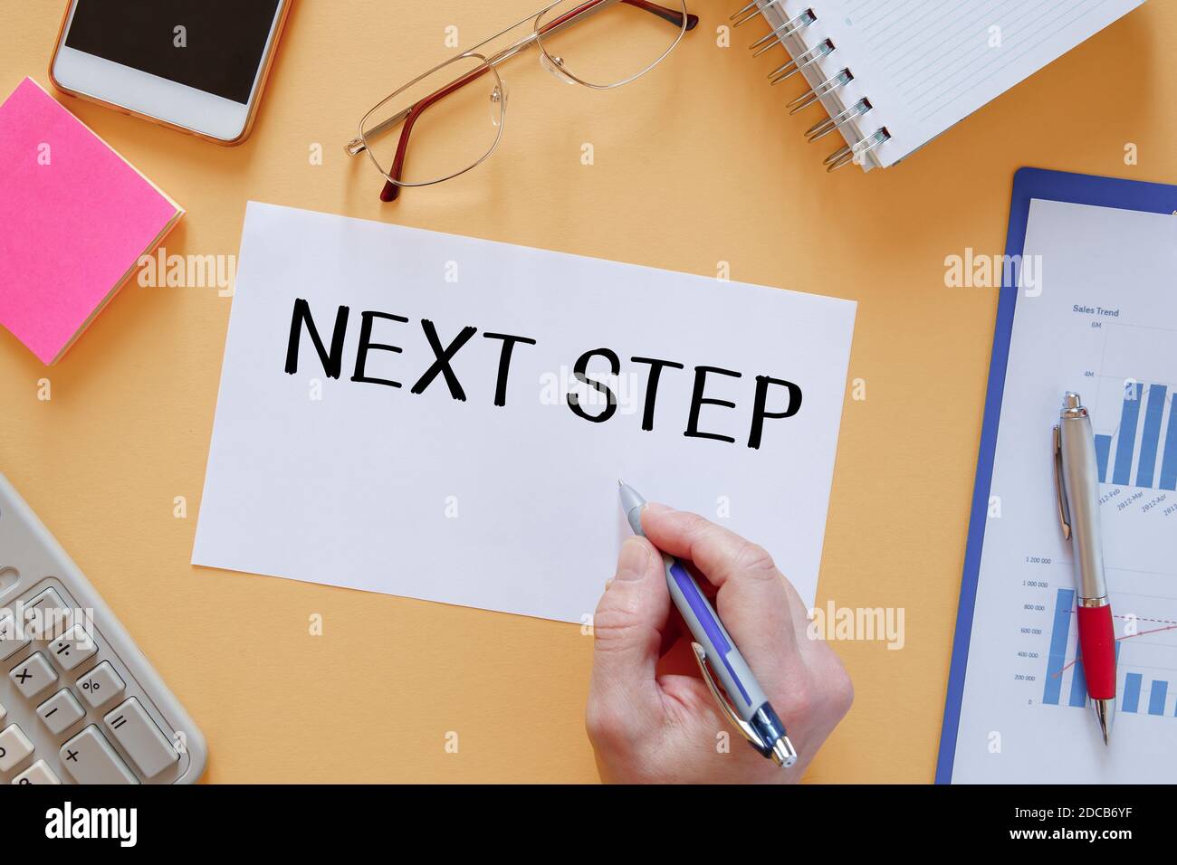 Paper with the text NEXT STEP on the office table among the stationery ...