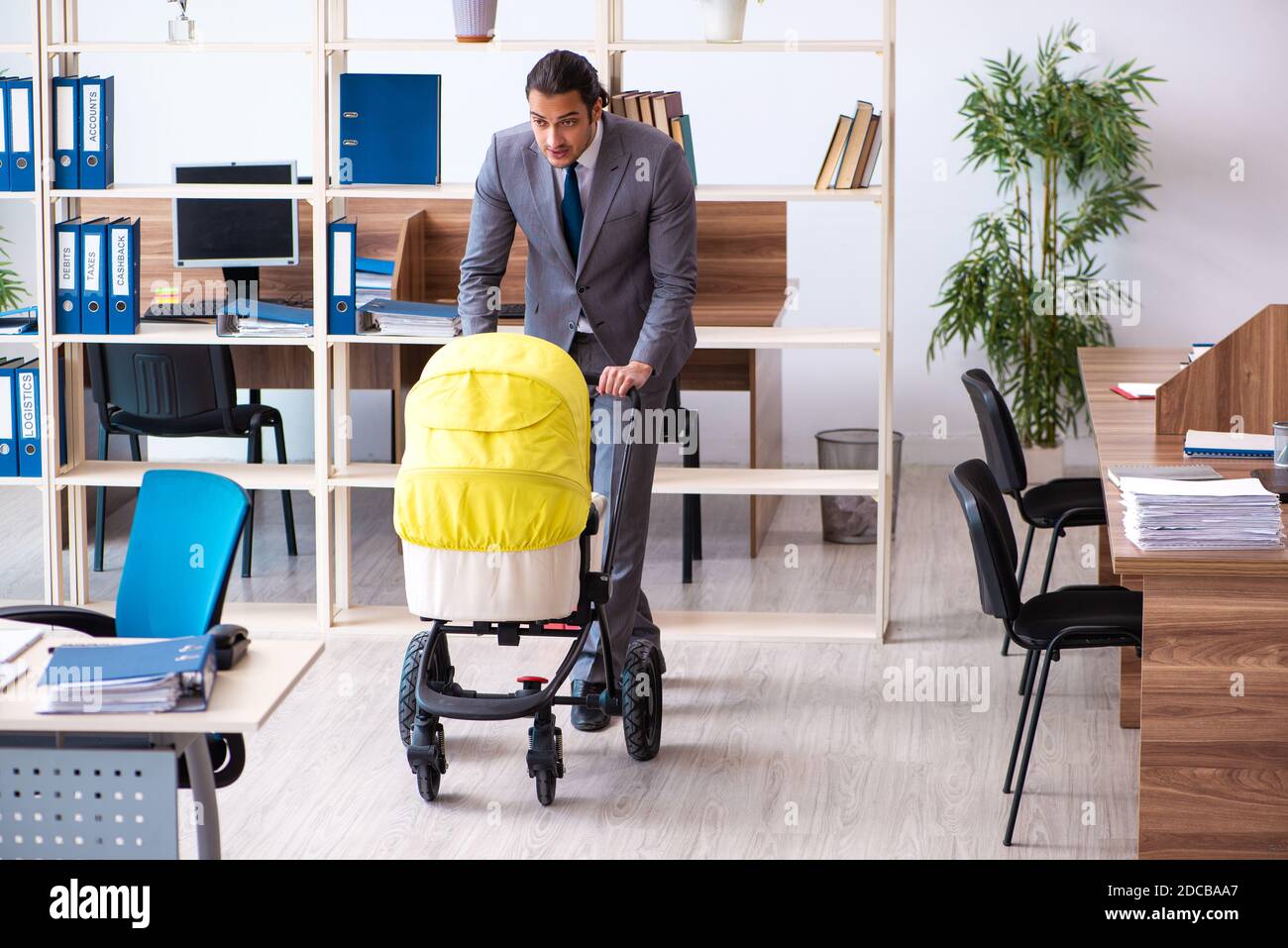 Male employee looking after newborn at workplace Stock Photo - Alamy
