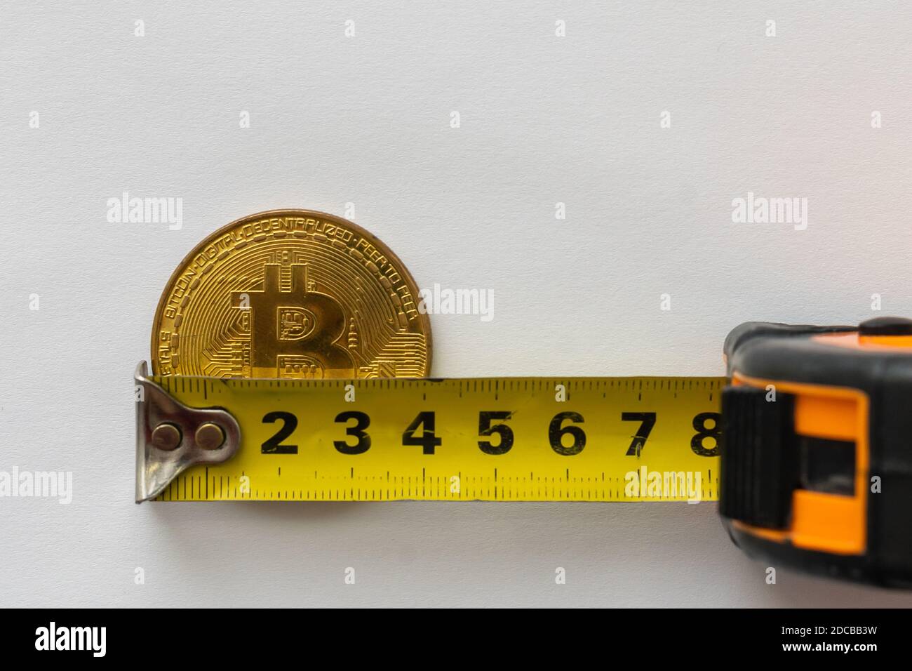 golden crypto coin in tape measure background Stock Photo - Alamy