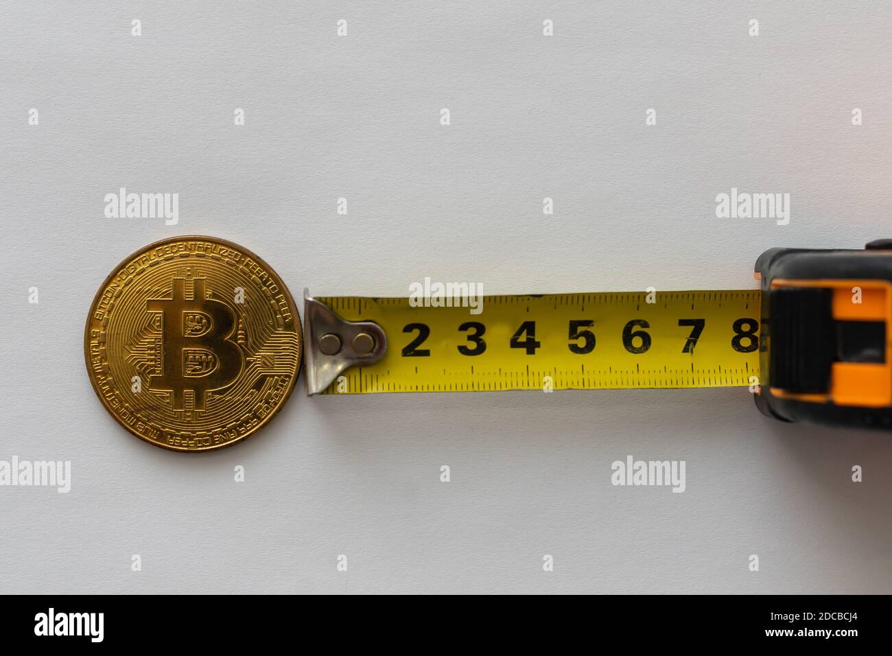 golden crypto coin in tape measure background Stock Photo - Alamy