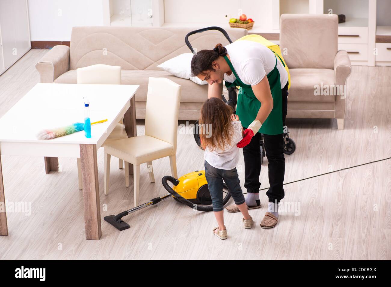 Young contractor cleaning the house with his small daughter Stock Photo ...