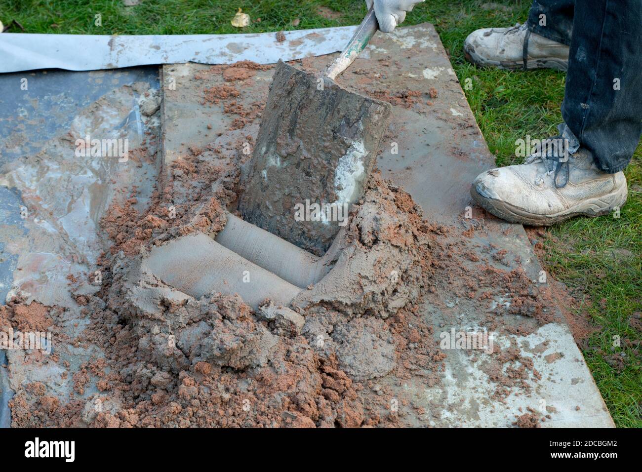 close up of bricklayer's hand scooping up mortar on his bricklaying ...