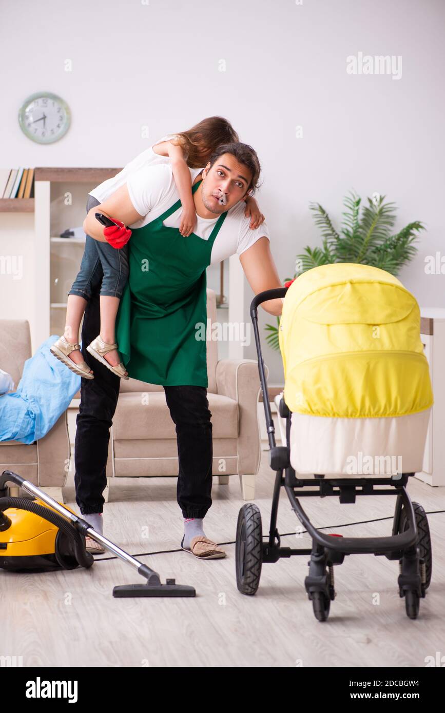 Young contractor cleaning the house with his small daughter Stock Photo ...