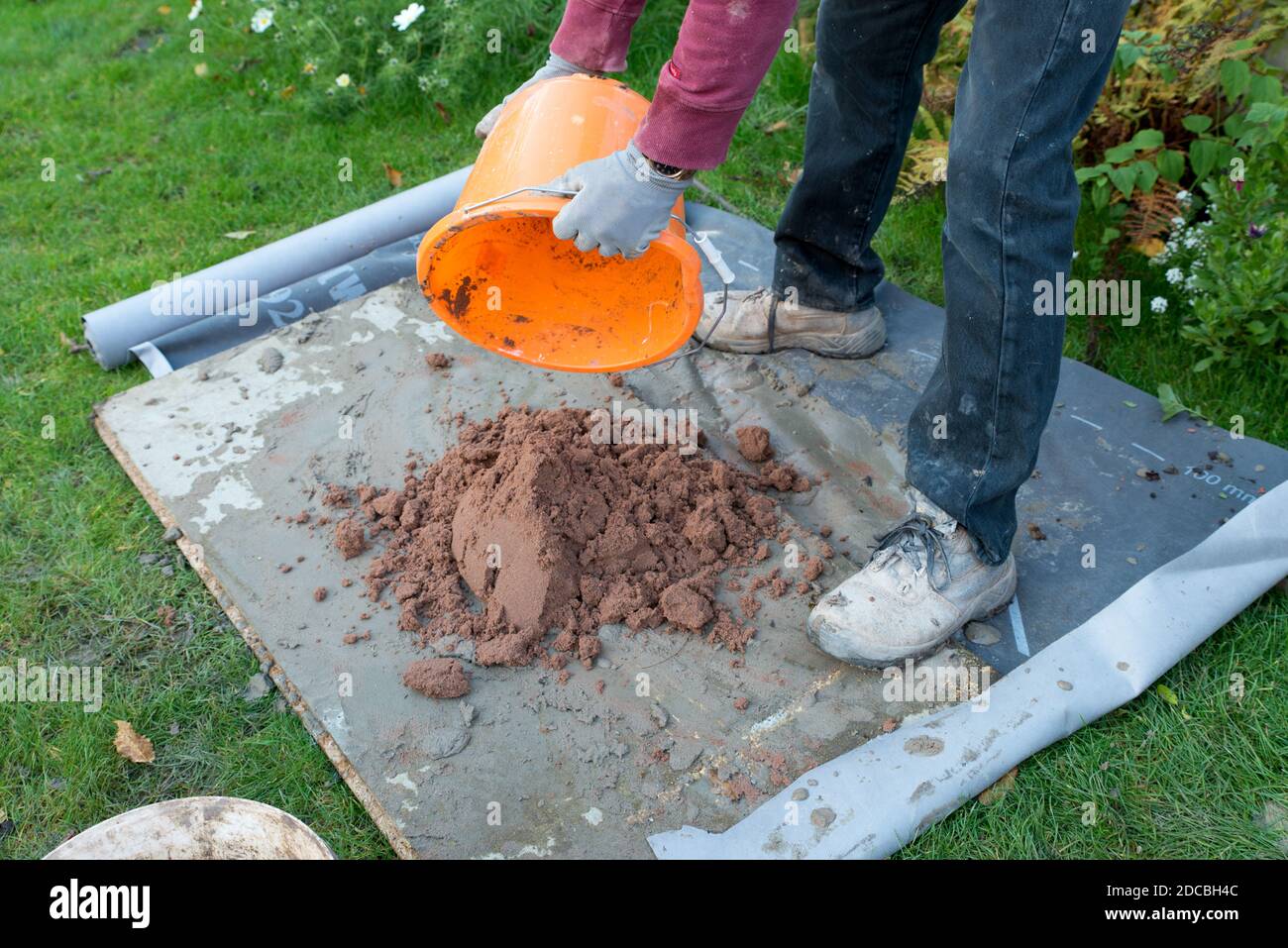 close up of worker making mortar with sand and cement. Builder with ...