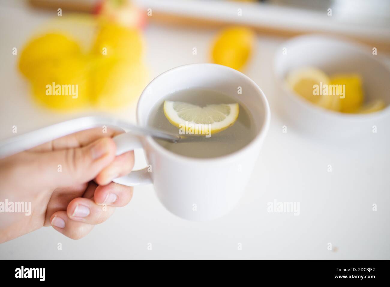 Hand holding a cup of lemon tea with a straw and lemon slice Stock ...