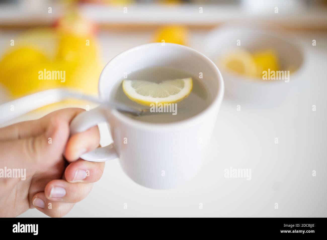 Hand holding a cup of lemon tea with a straw and lemon slice Stock ...