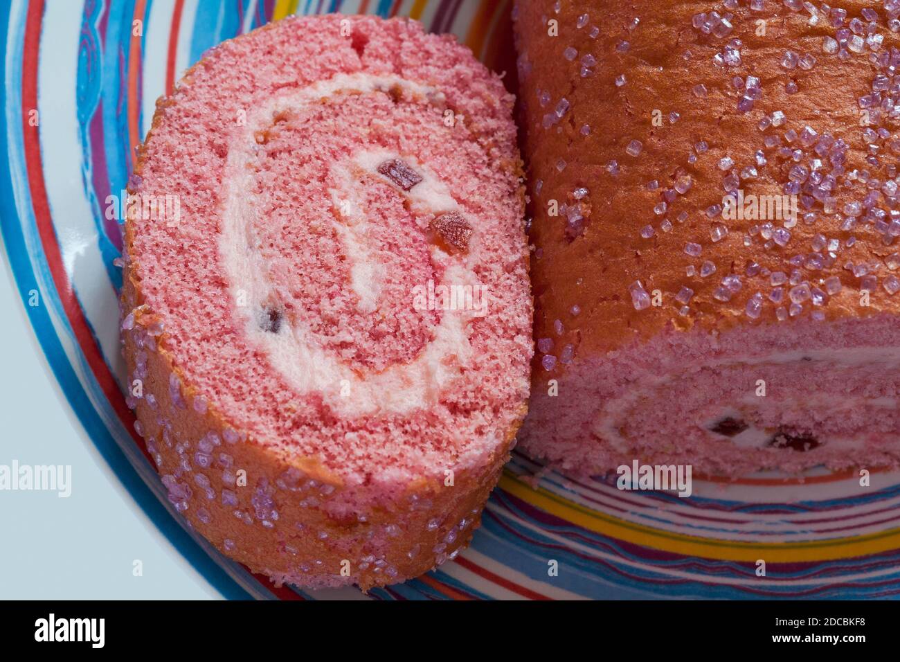 slice cut off of M&S Percy Pig sponge roll cake on plate - pink sponge ...