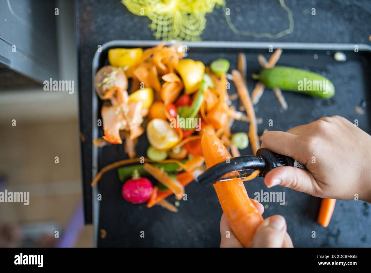 Female hands peeling a carrot on top of organic trash Stock Photo - Alamy