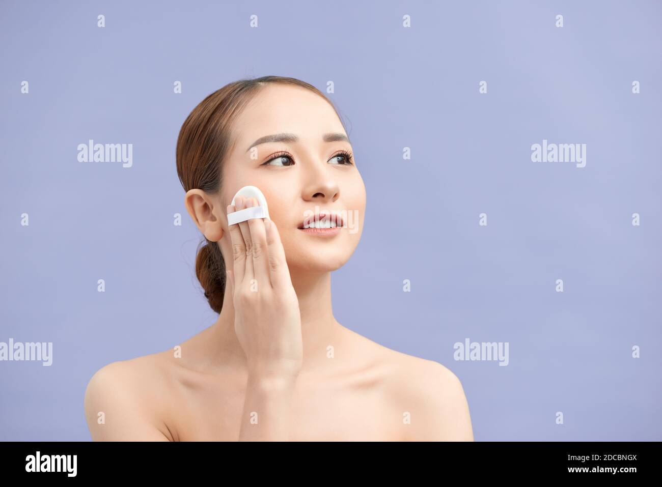 Beautiful woman applying dry powder using cosmetic cushion on her ...