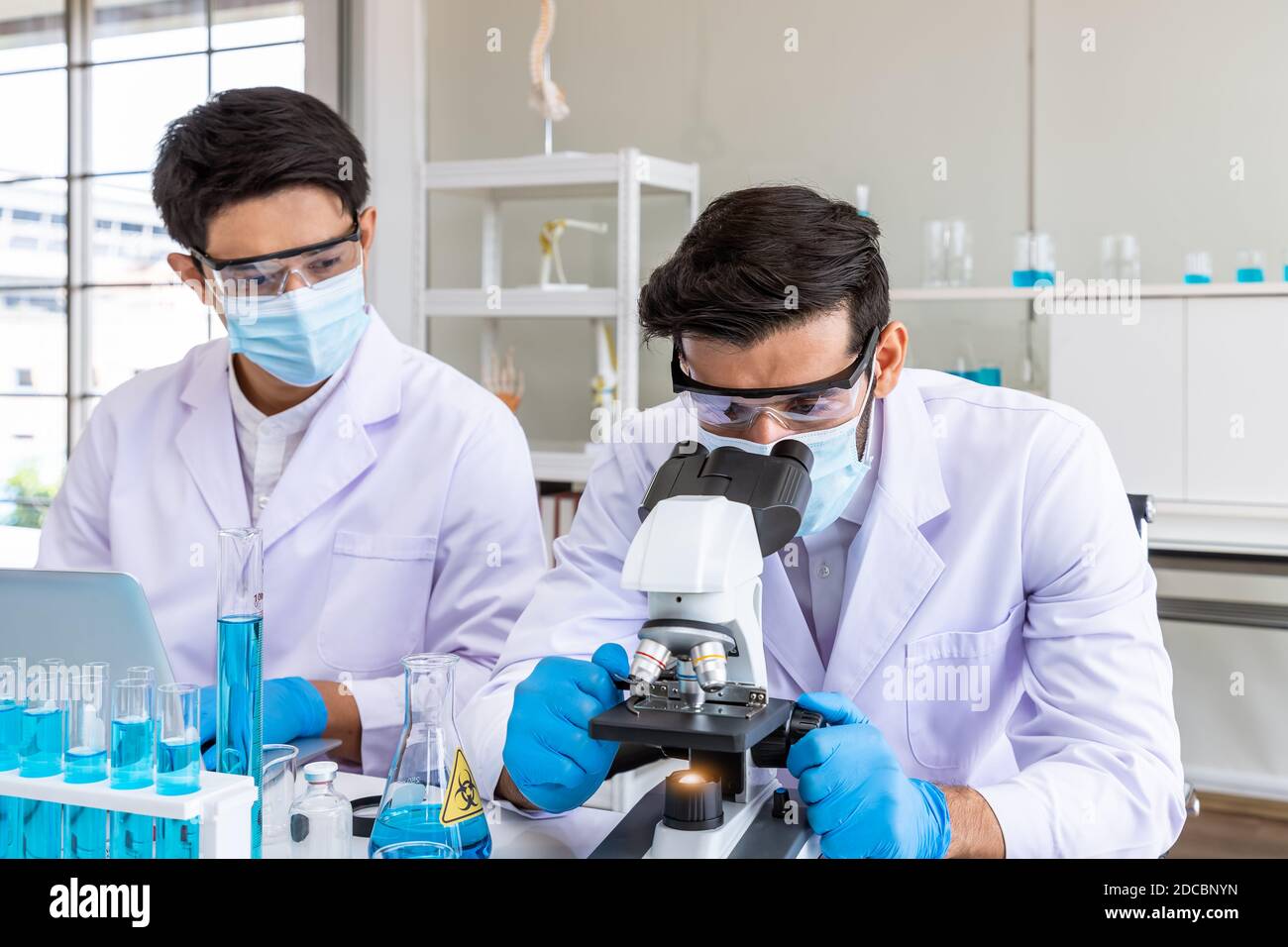 Two male Asian and Arab researcher scientists working in laboratory ...