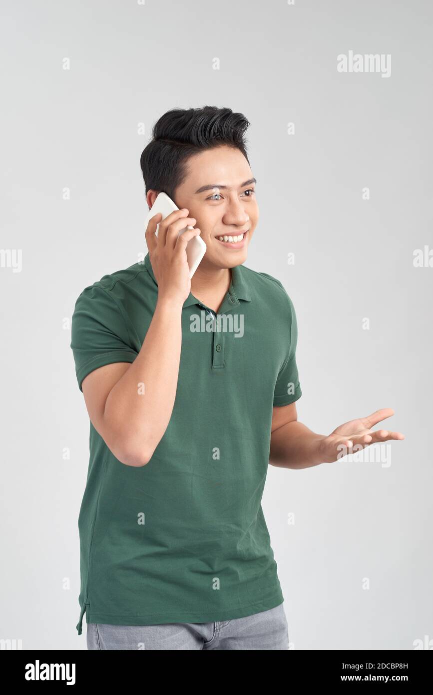 Young handsome man talking on cellphone, excited, rejoicing, isolated ...