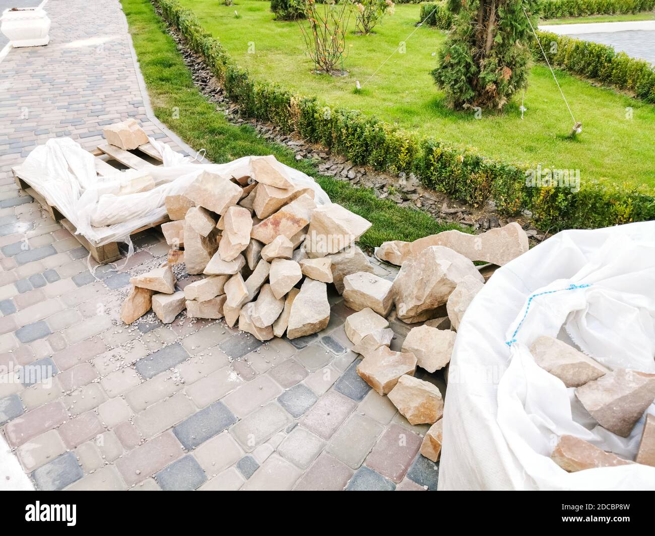 industrial worker installing pavement rocks, cobblestone blocks on road ...
