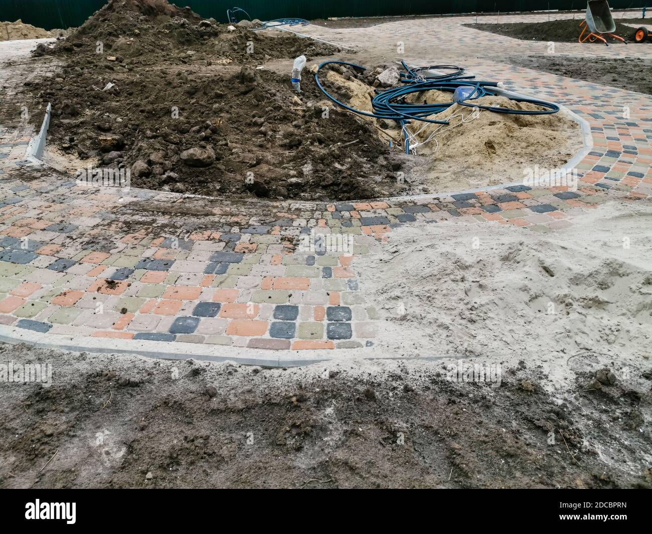 industrial worker installing pavement rocks, cobblestone blocks on road ...