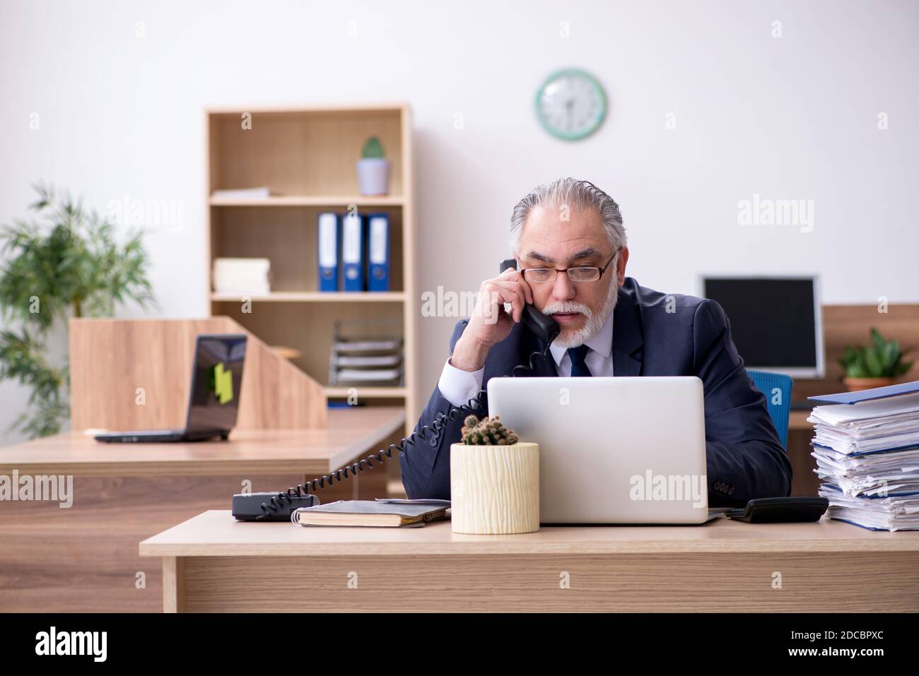 Old employee working in the office Stock Photo - Alamy