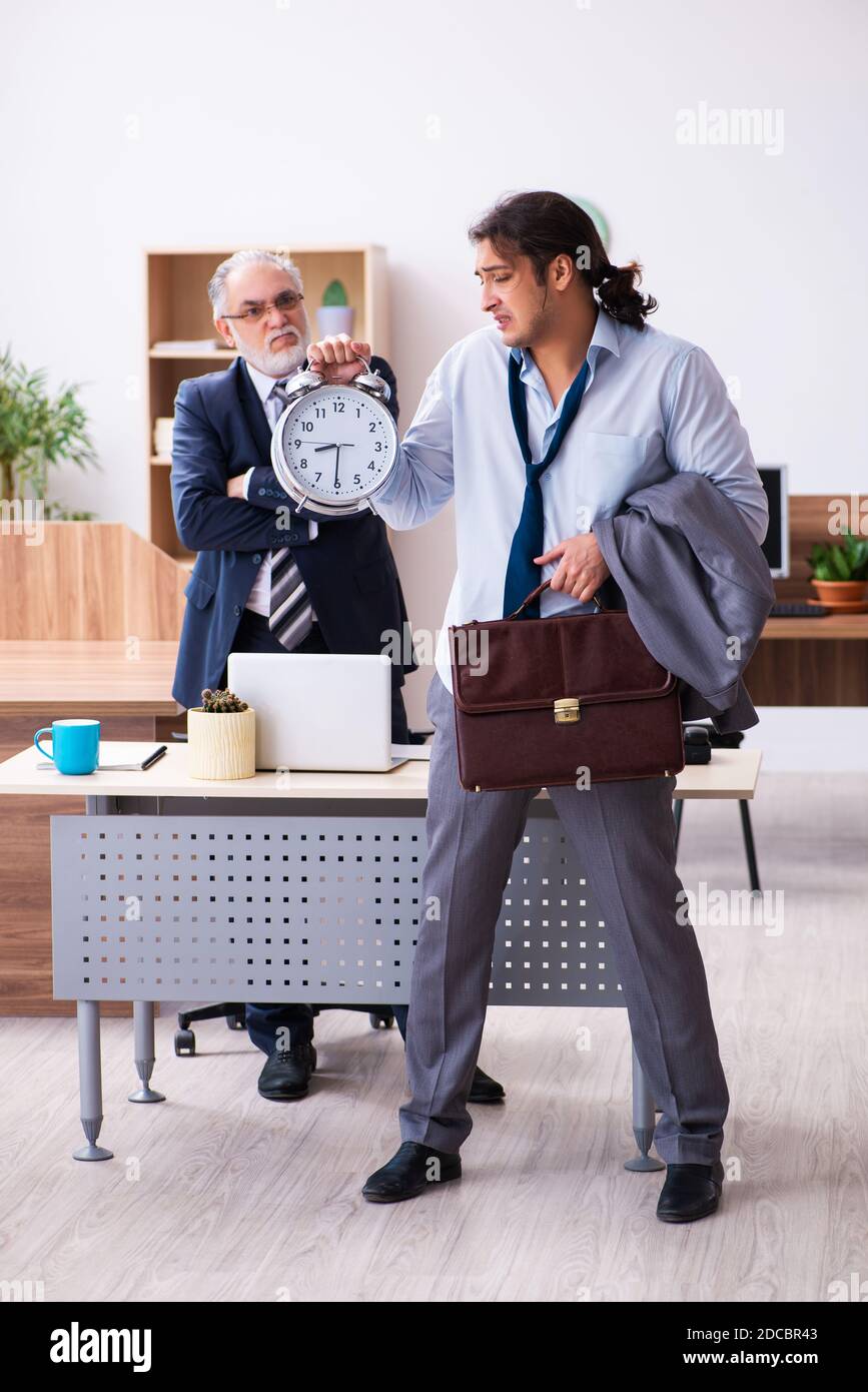 Old boss and young male employee in time management concept Stock Photo ...