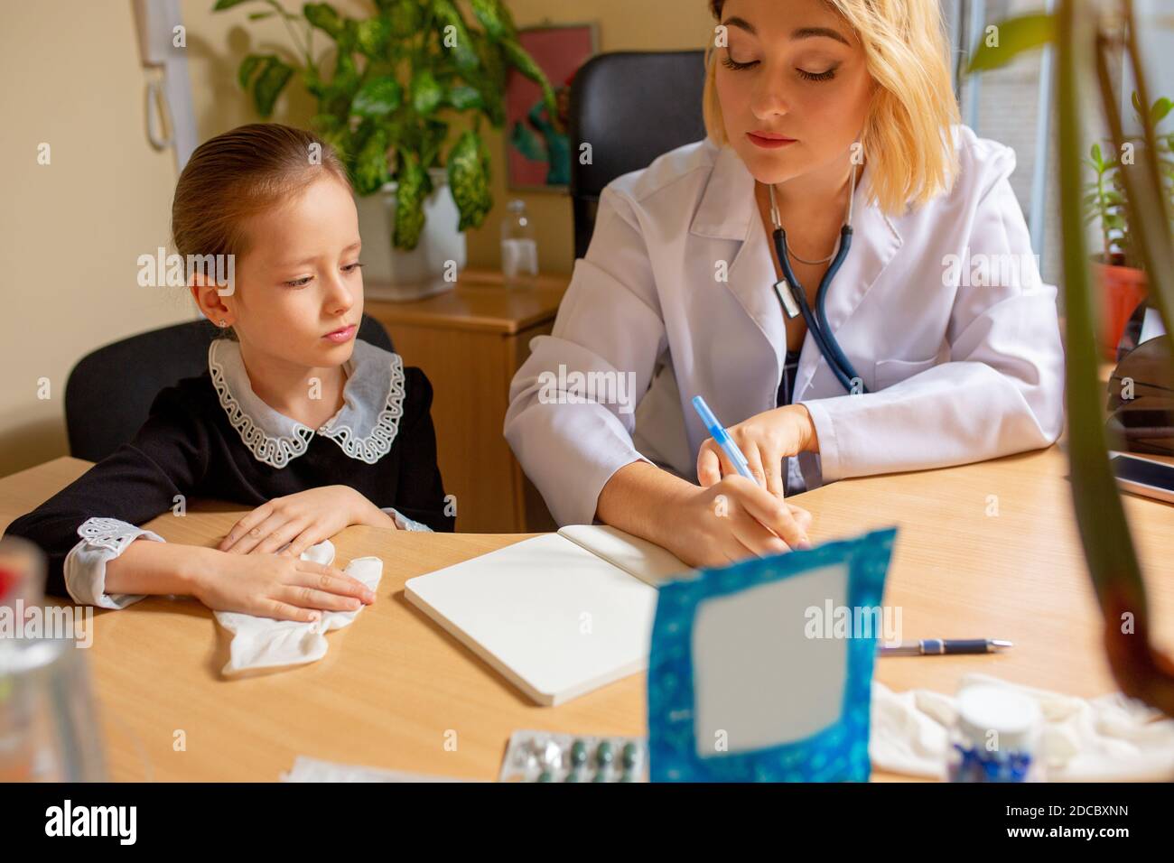 Paediatrician doctor examining a child in comfortabe medical office ...