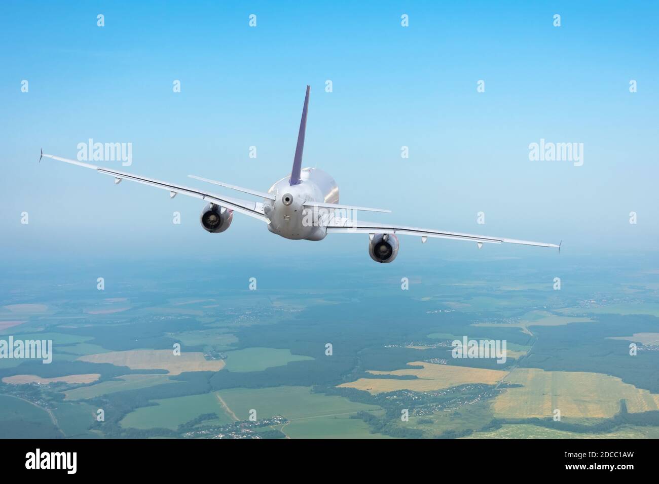 Airplane flying away into the distance in a clear sky not high above ...