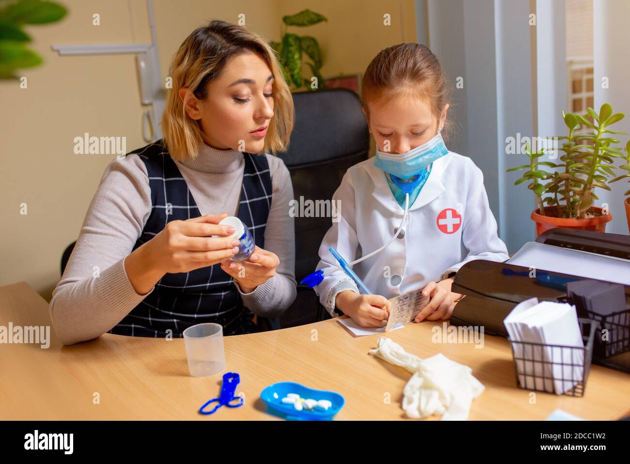 Little girl playing pretends like paediatrician doctor examining a ...