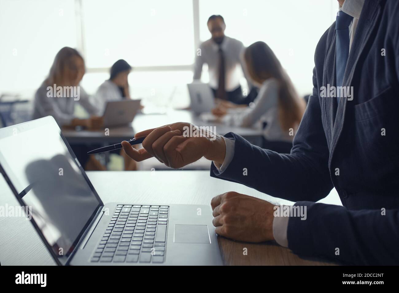 Male hand holding pen pointing computer screen. Businessman working on ...