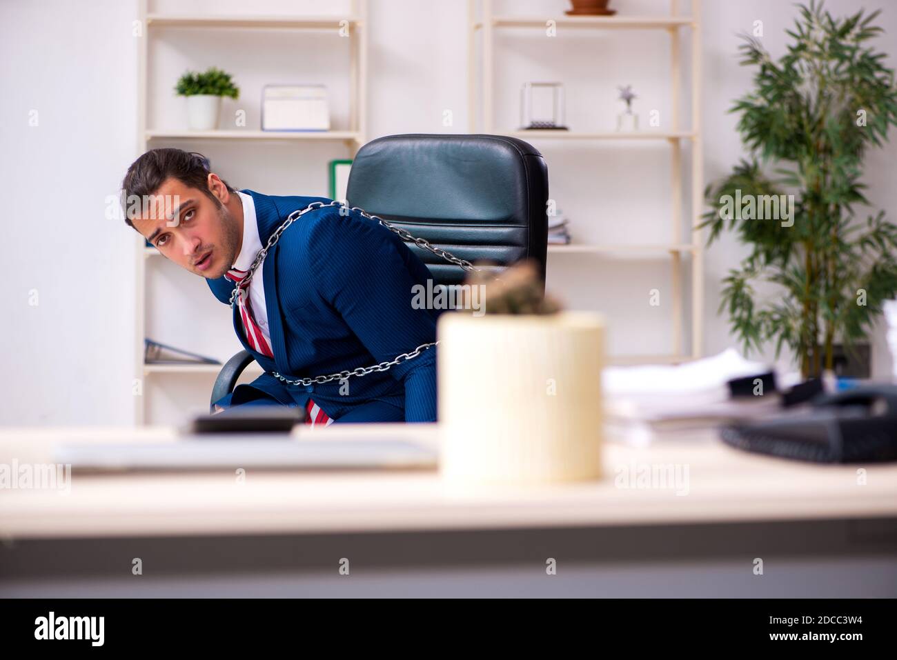 Chained employee working in the office Stock Photo - Alamy