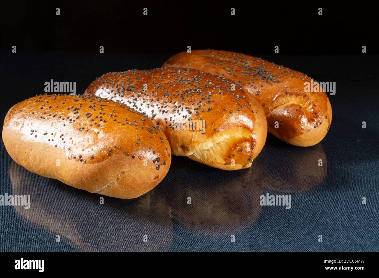 Bread on table with reflection on black background. Baking products ...