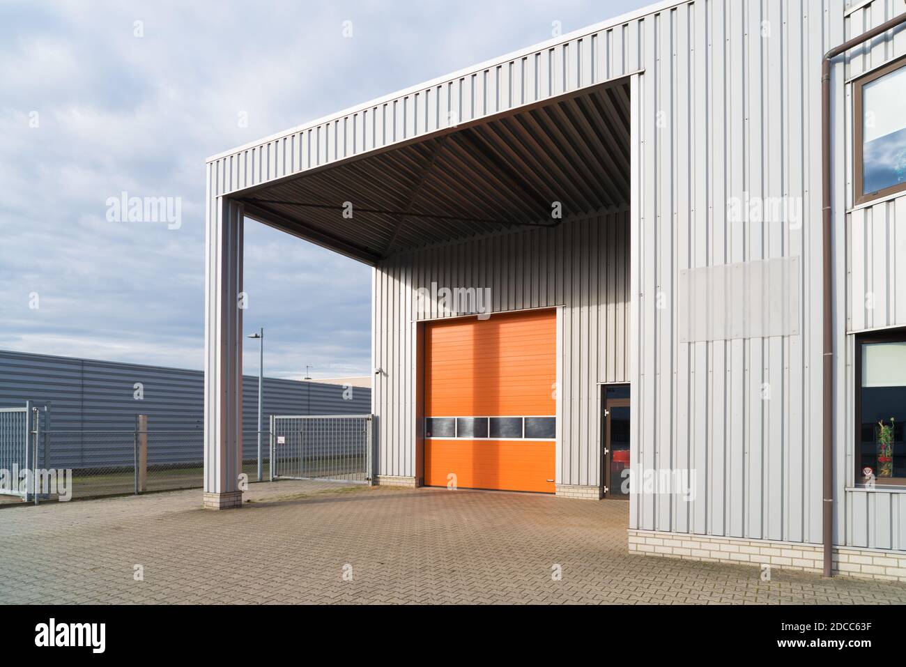 industrial warehouse with orange roller door Stock Photo - Alamy