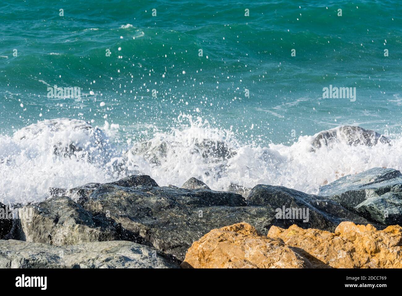Waves of Persian Gulf splashing the stones of breakwater at the ...