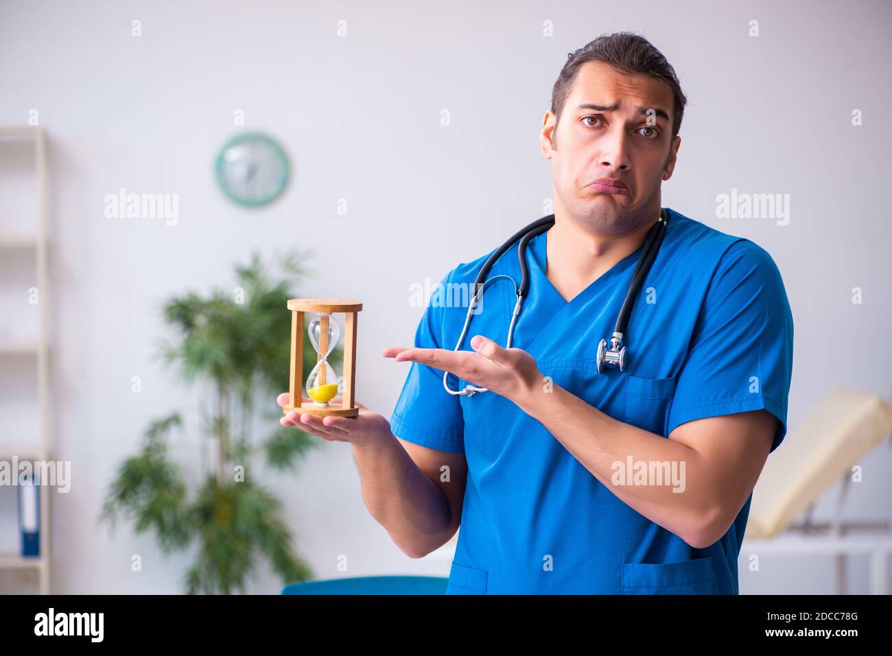 Young doctor in time management concept Stock Photo - Alamy