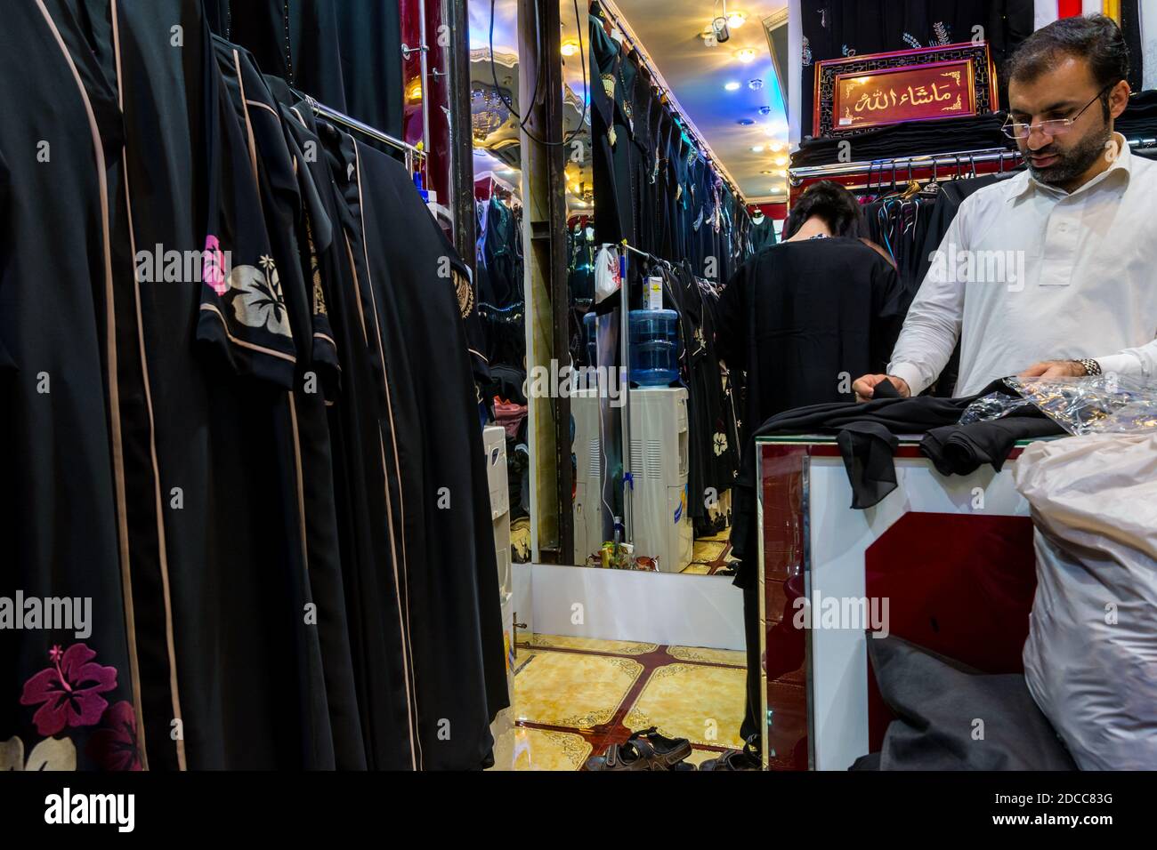 An Arabian man selling clothes at an Arabian traditional cloth Hijab ...