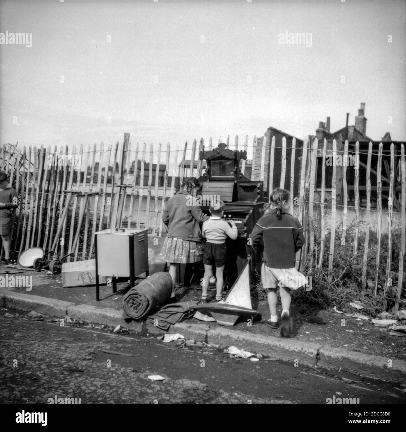 Children play on an organ at the side of the road in Vallance Road in ...