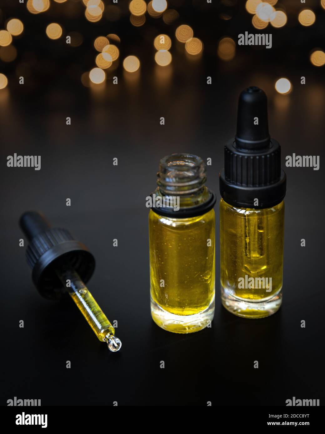 CBD oil drops over moody dark background with dim lighting Stock Photo ...