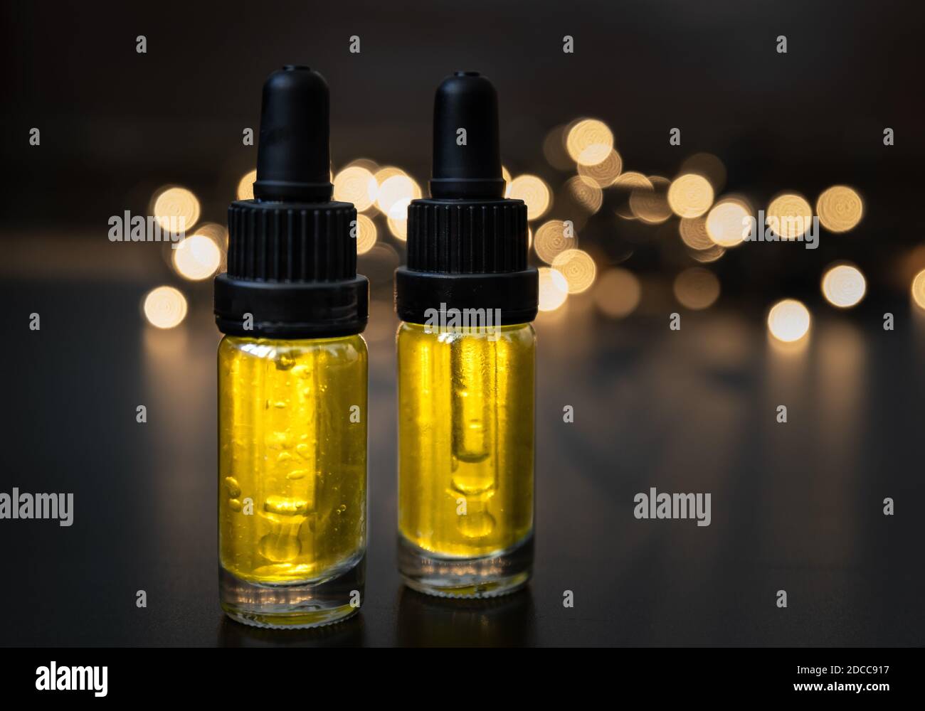 CBD oil drops over moody dark background with dim lighting Stock Photo ...