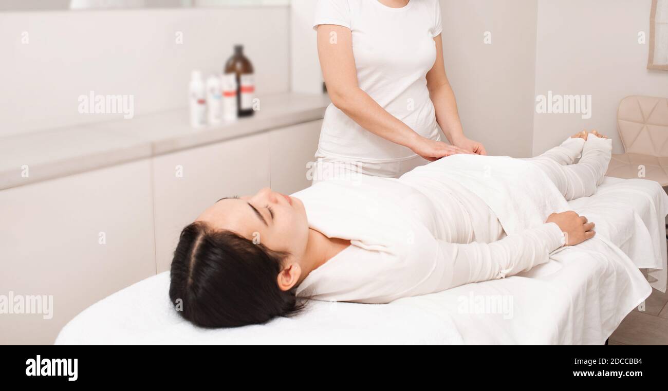 Asian woman during anti-cellulite bandage wrap procedure. Wet whiskey ...