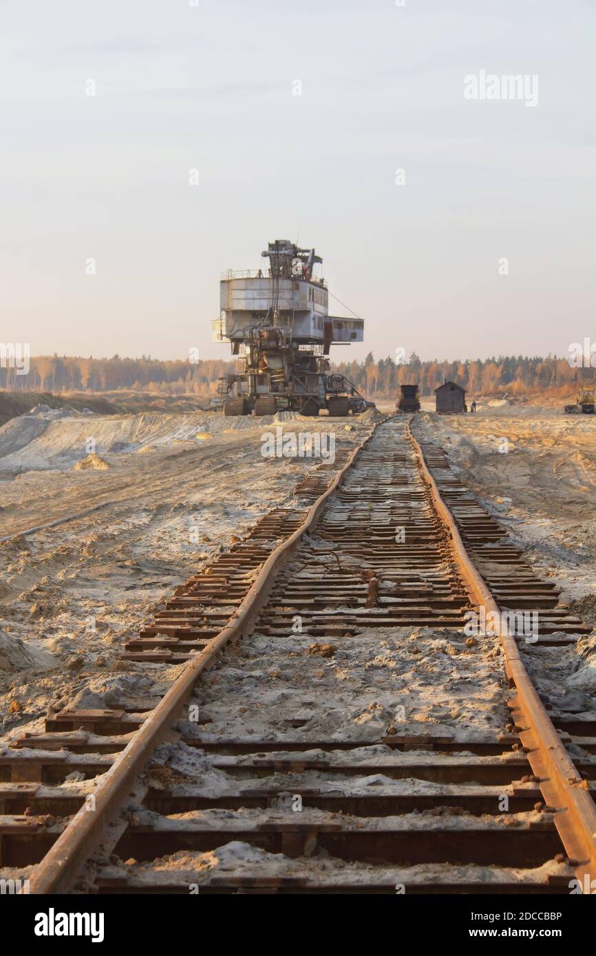 Rusty railroad tie. Giant stacker. Bucket chain excavator in a sand ...