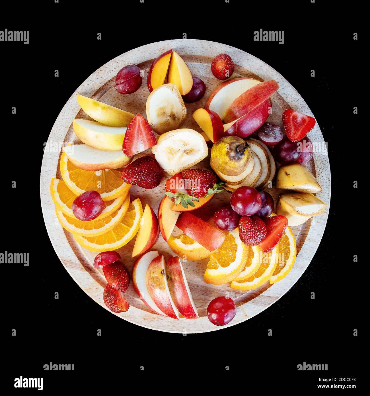 Fruit cutting on a plate. Apelsygs, grapes, apples and strawberries ...