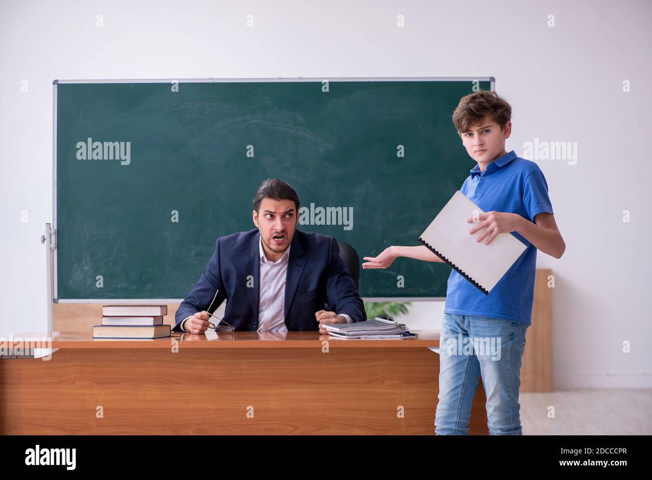 Male teacher and schoolboy in the classroom Stock Photo - Alamy